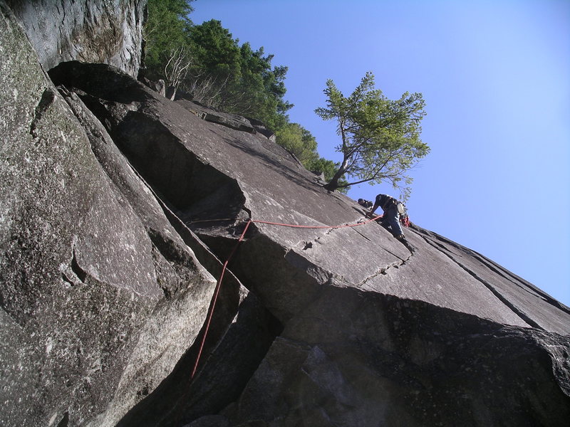 A climber about half way up the Great Northern Slab. Pisces is the ...