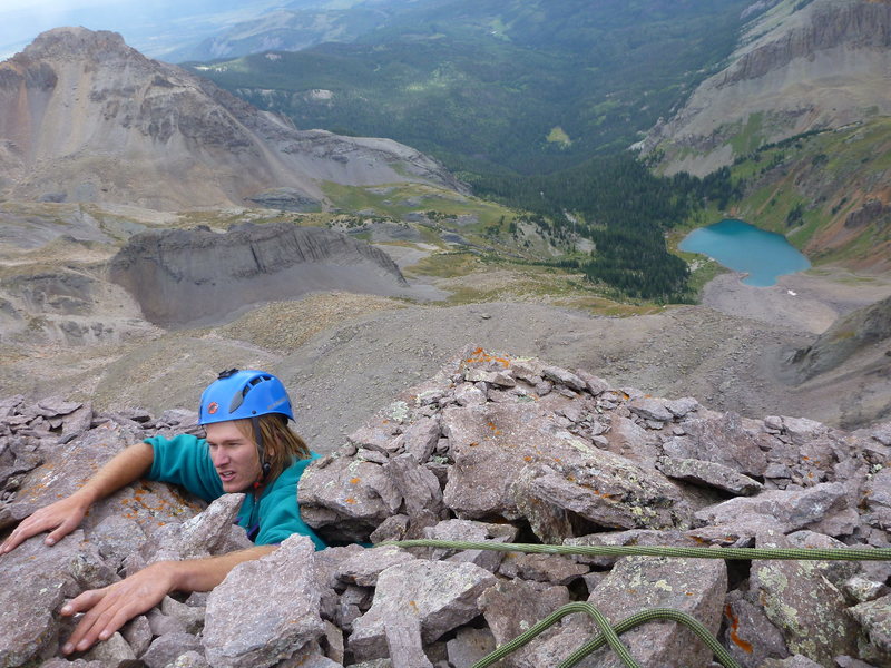 Greg making the last choss mantle moves to the top of Dallas Peak.