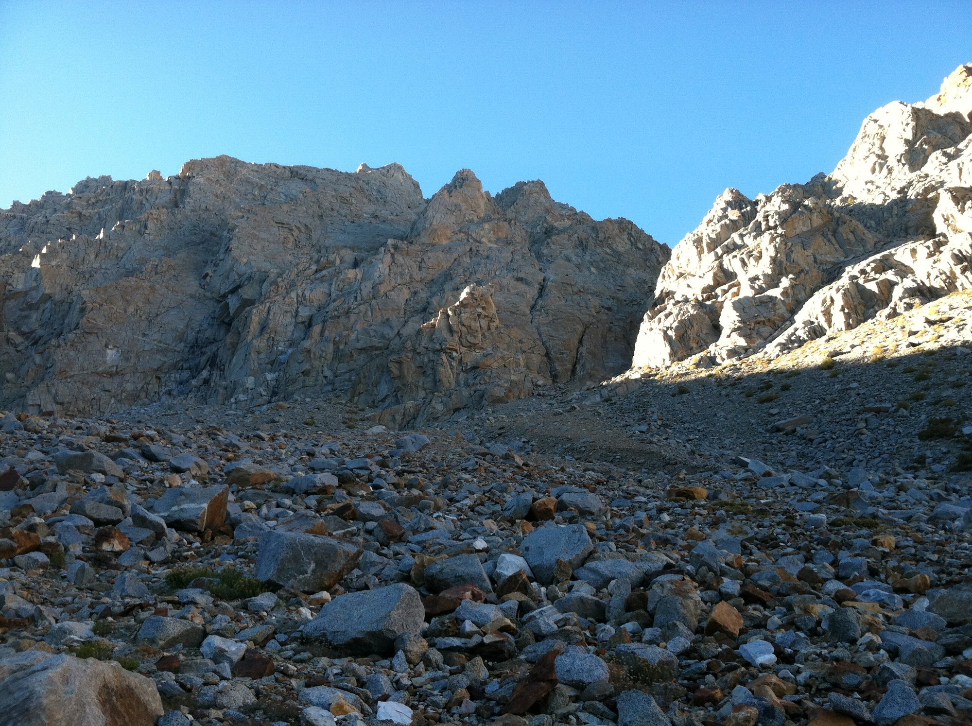 Looking up easy talus field to start of climb. Pitch 1 starts in the ...