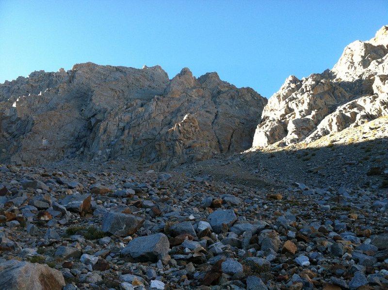 Looking up easy talus field to start of climb. Pitch 1 starts in the ...