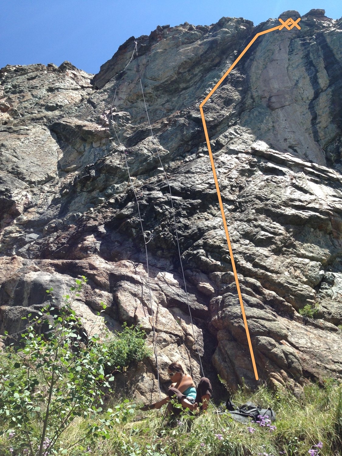 The line goes up right of the rope and traverses under the rotten roof.