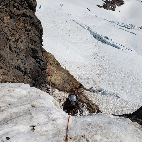 Topping out the first ice pitch with the Eliot Glacier below.