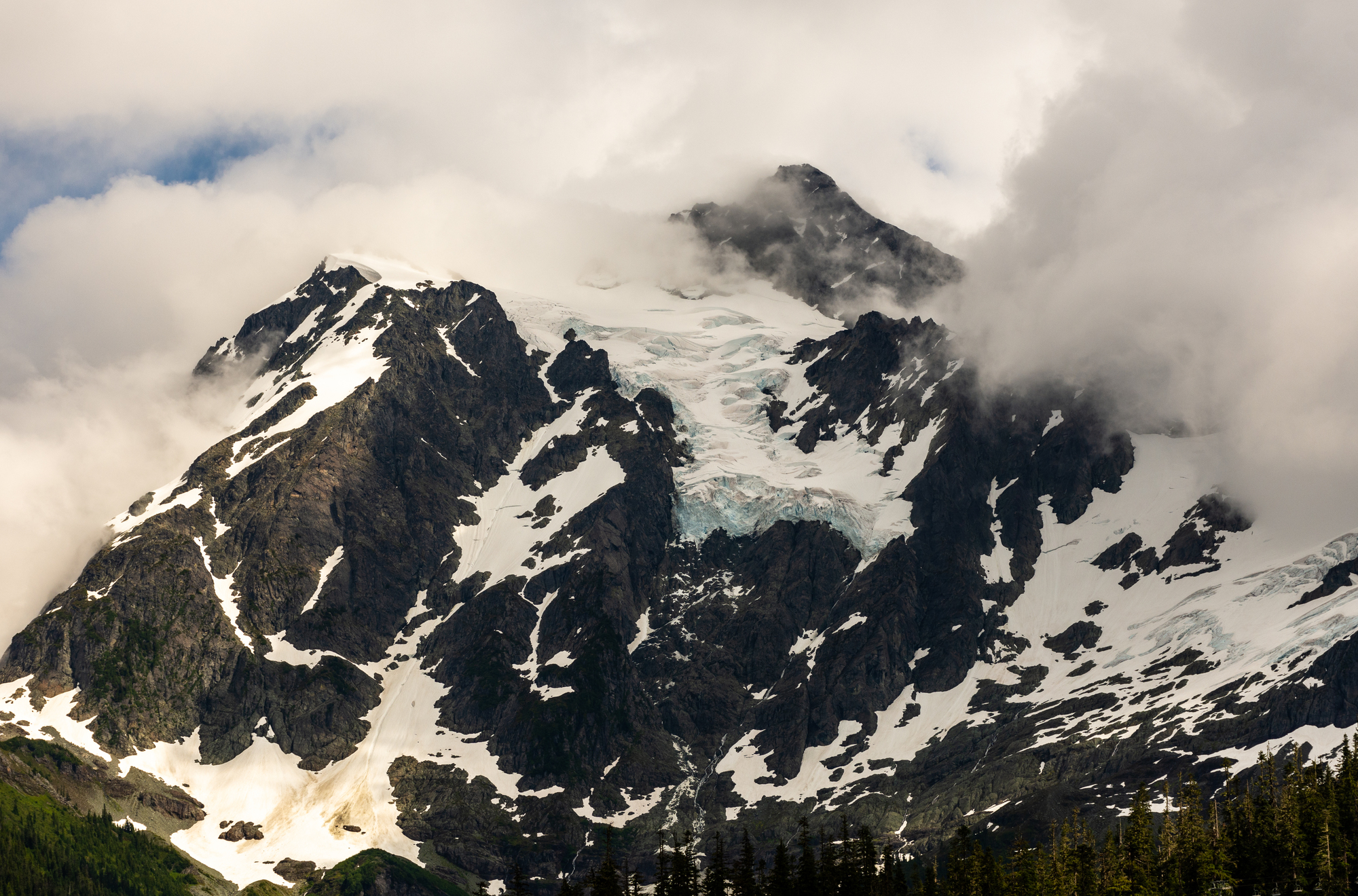 Mt. Shuksan's summit pyramid peeking through the clouds.