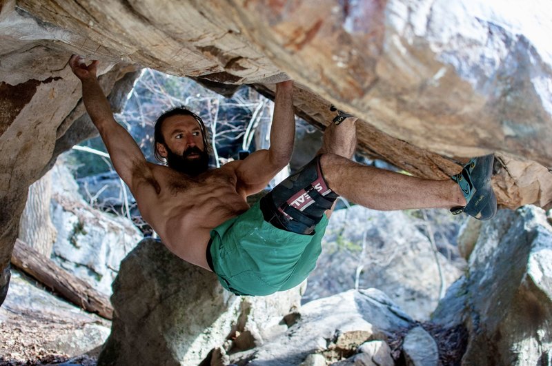 Climbing feet-first through the roof portion of 300 (V9). Climber ...