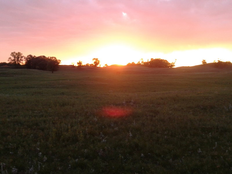 Sunset over the prairie covered sandhills.
