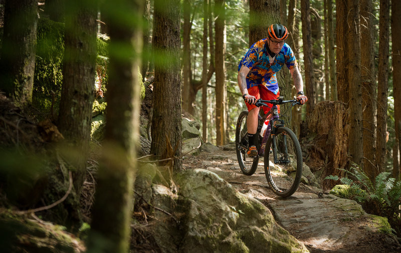 A brightly colored rider navigates a short rock ramp on the Raptor ...